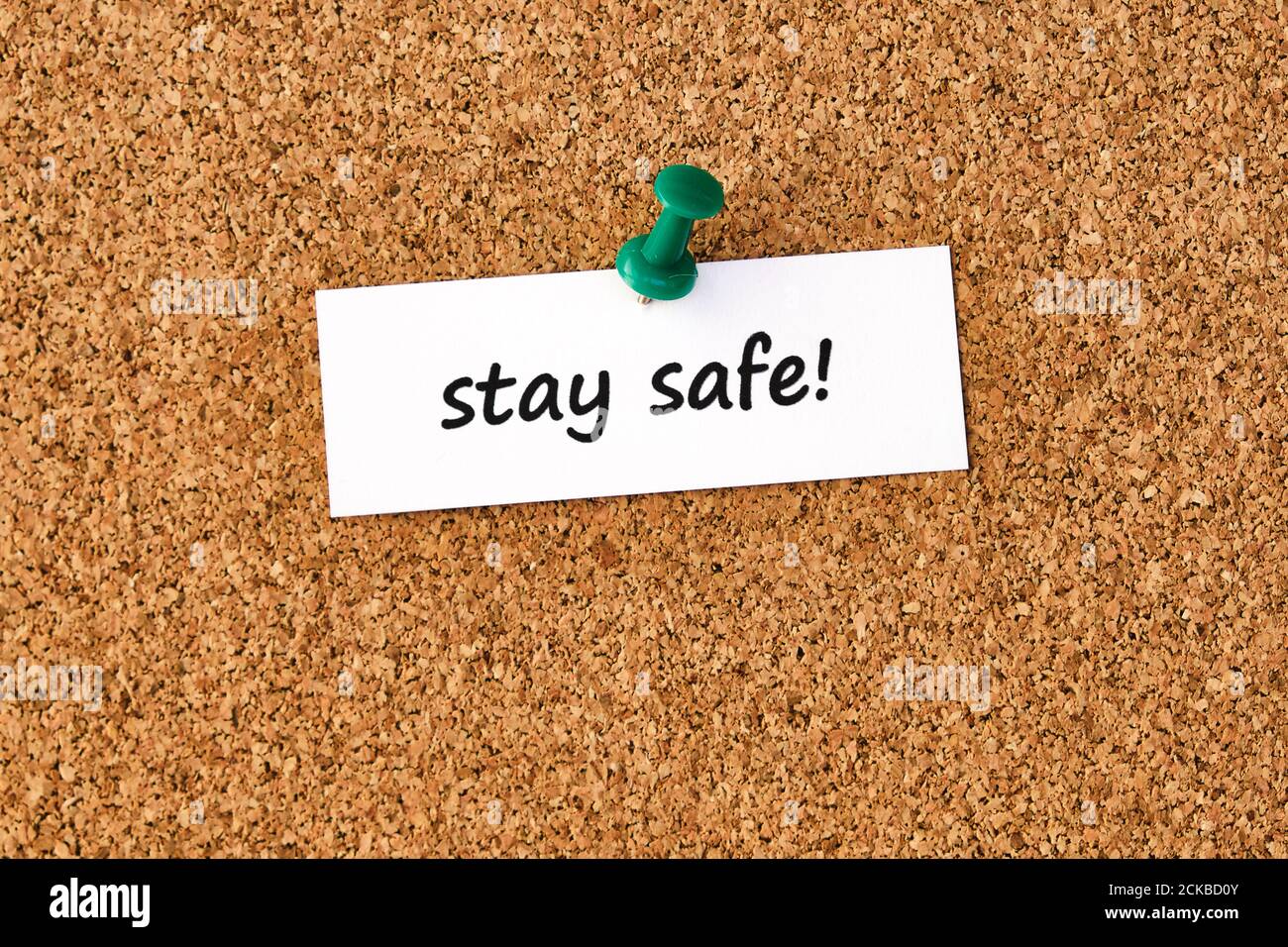 Stay safe. Text written on a piece of paper or note, cork board ...