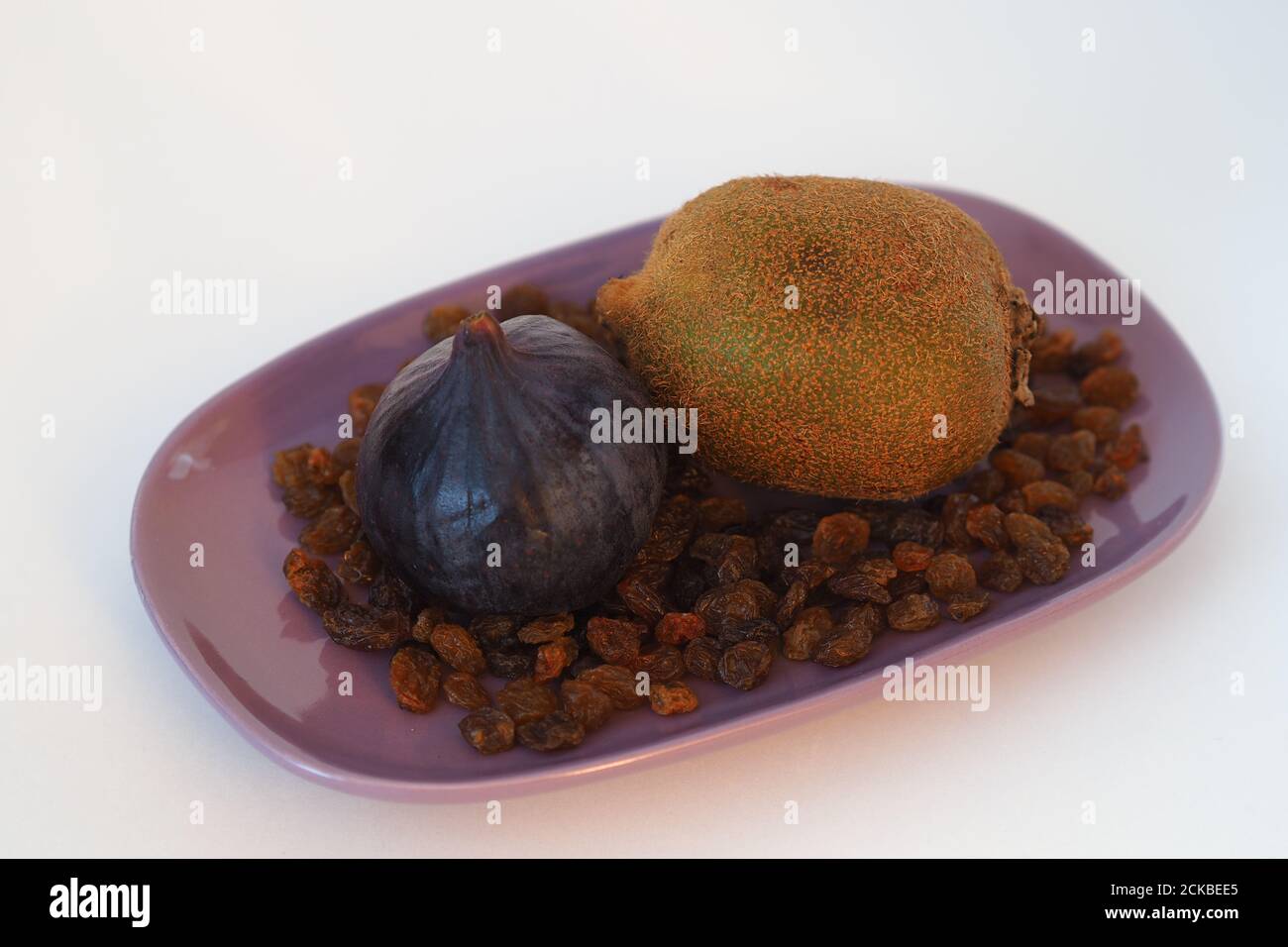 Fruit. Fig and raisins on a platter. White background Stock Photo - Alamy