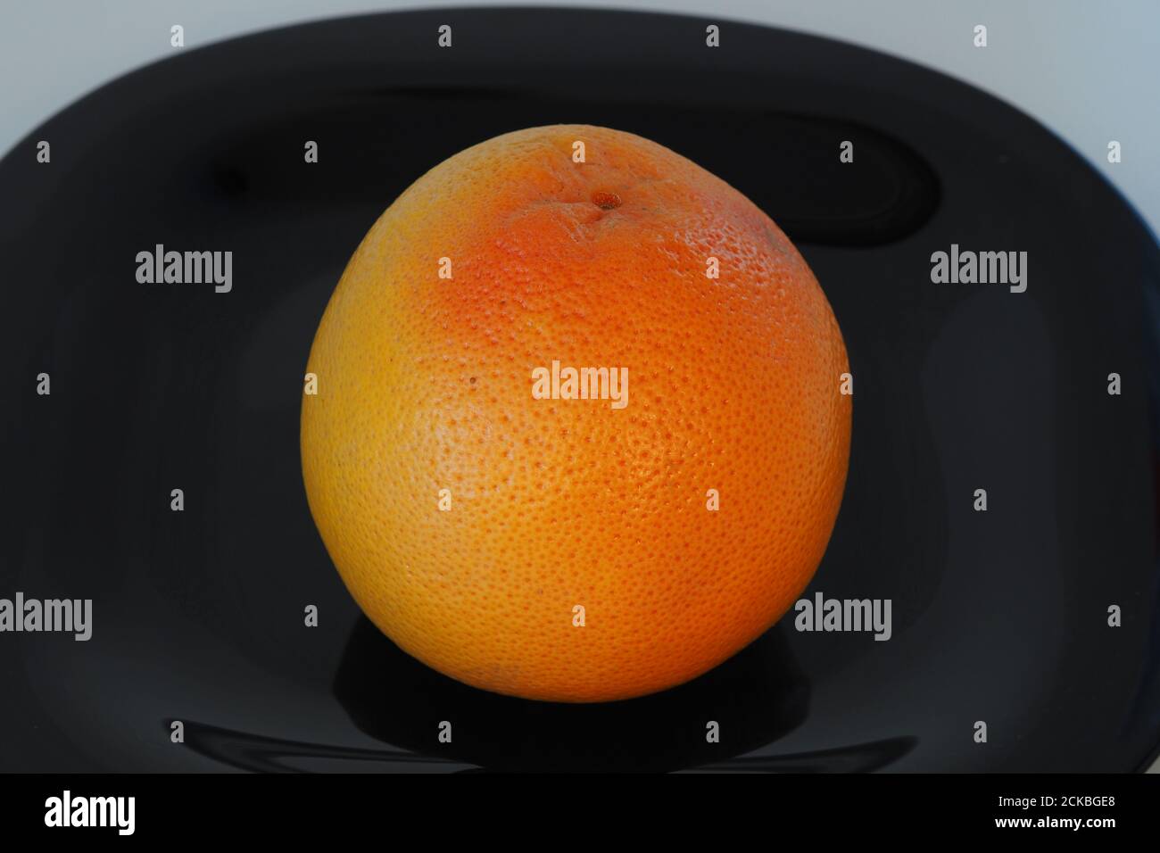 Fruits are citrus fruits. Orange grey fruit on a black plate Stock ...