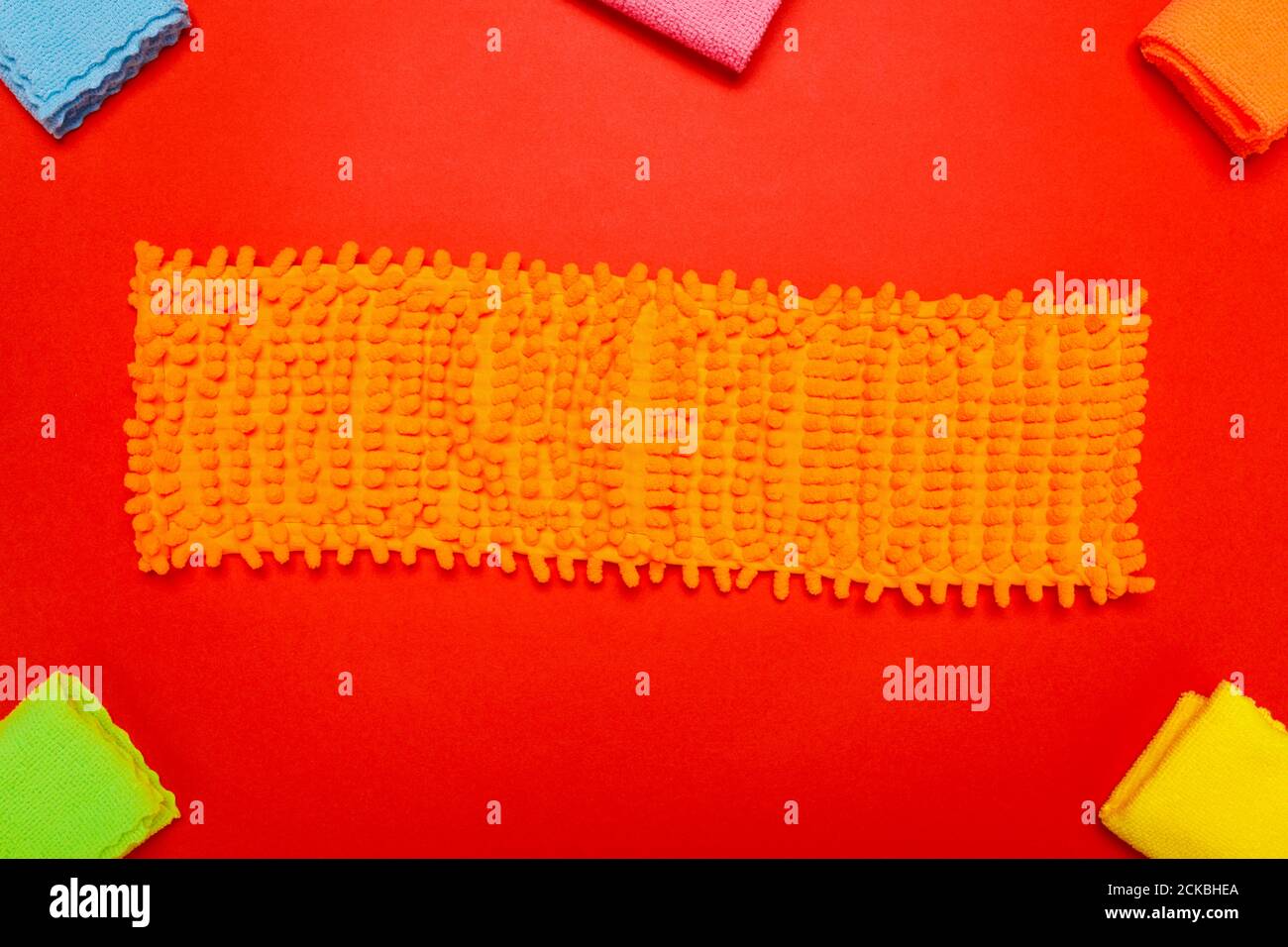 rags for cleaning. rags of different colors and a floor rag on a red ...