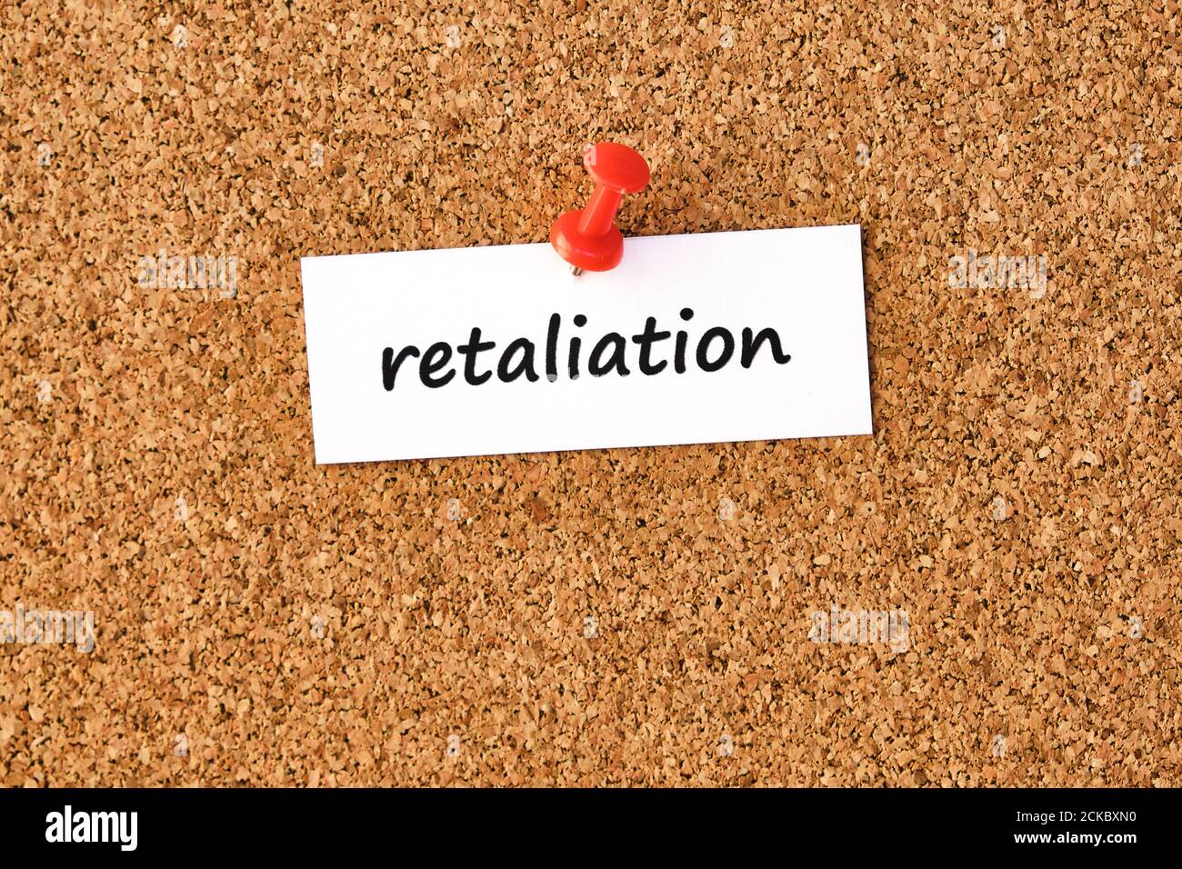 Retaliation. Word written on a piece of paper or note, cork board ...