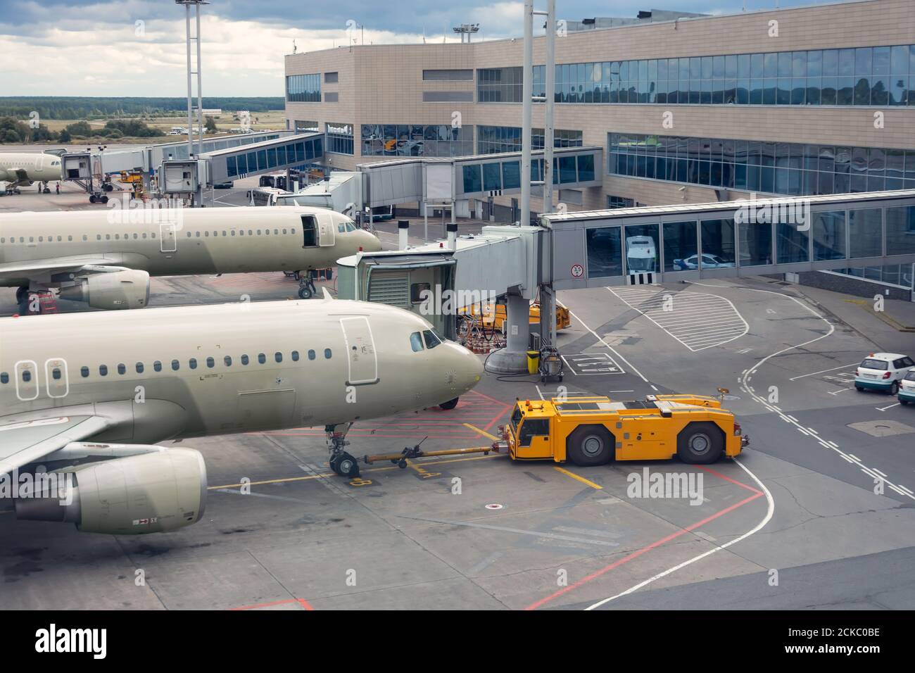 Pushback truck is towing the aircraft to a parking lot, a row of planes ...