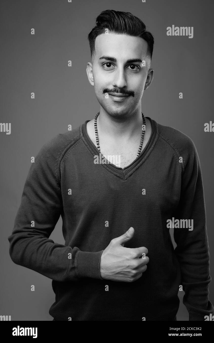Young handsome Iranian man with mustache against gray background Stock ...