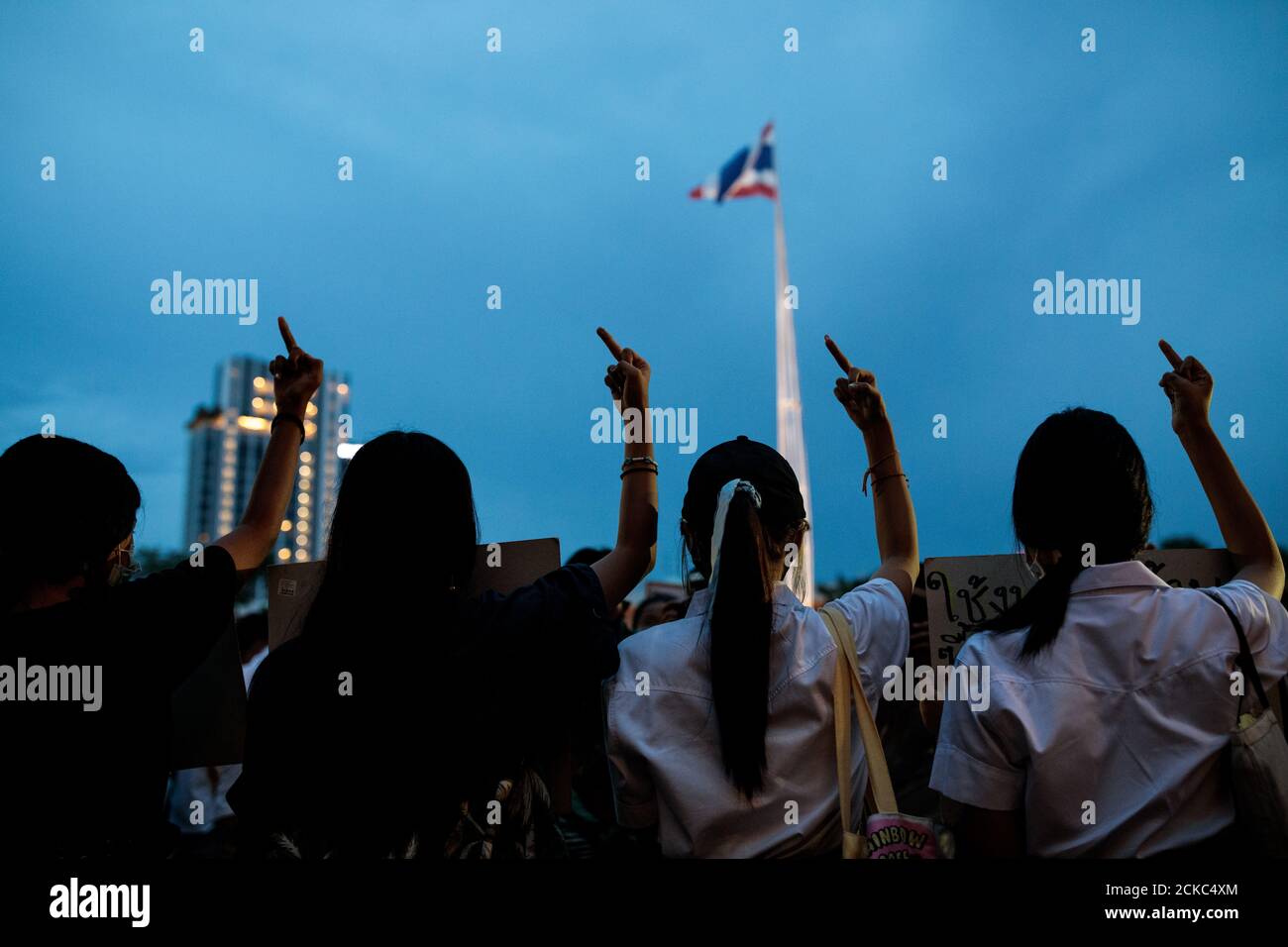 Middle fingers are held up in front of the Thai flag as students and ...