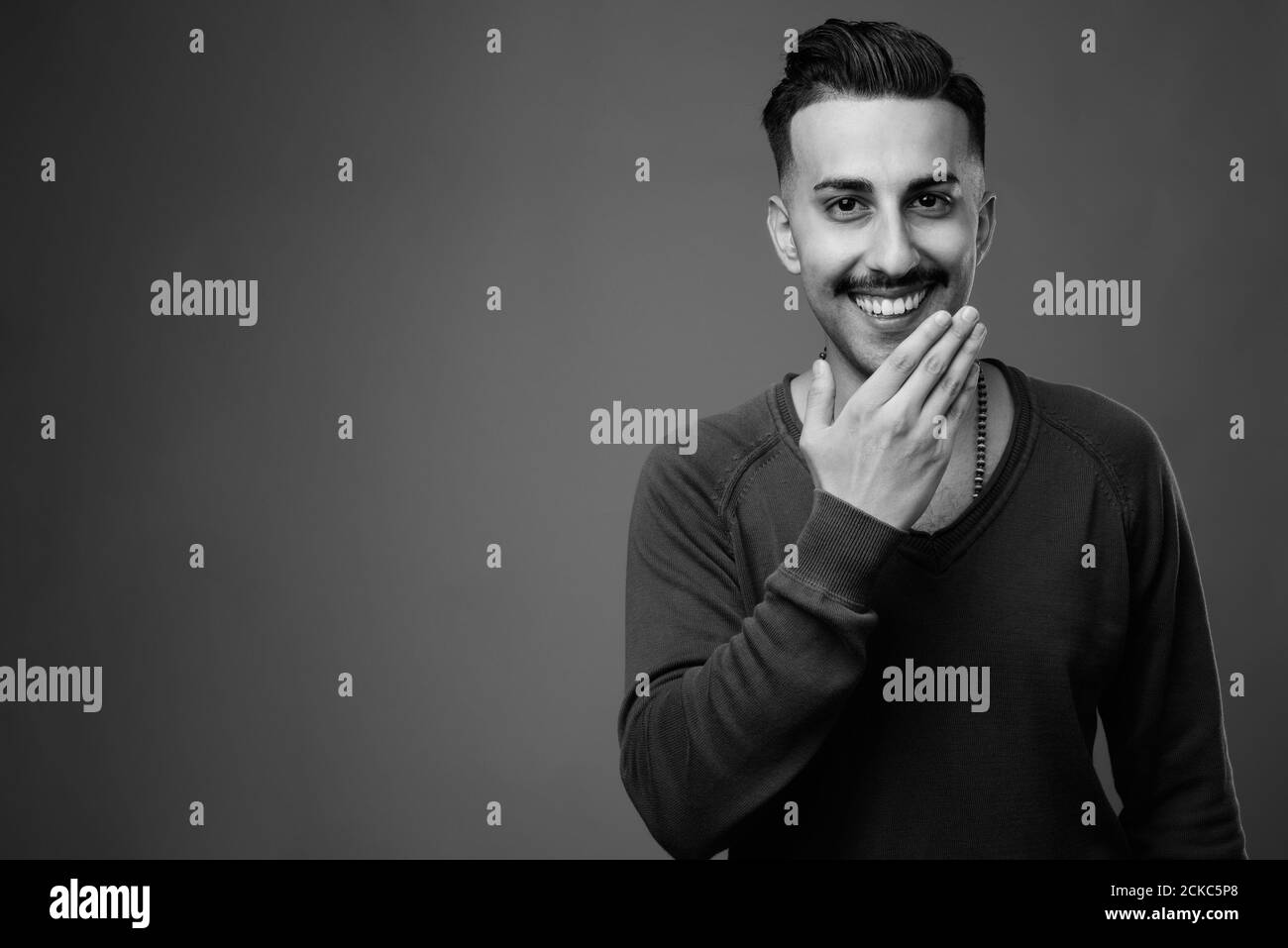 Young handsome Iranian man with mustache against gray background Stock ...