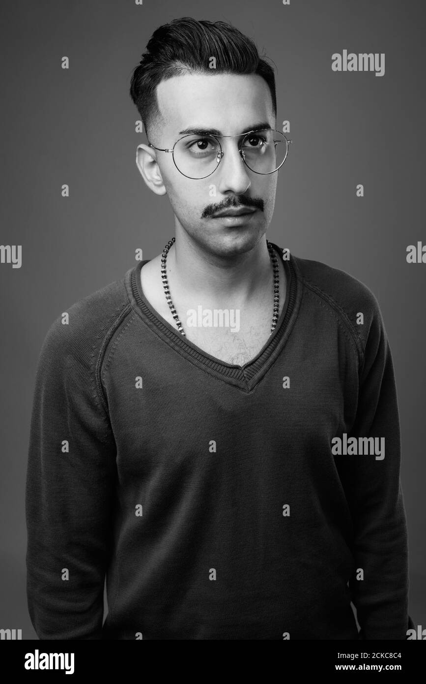Young handsome Iranian man with mustache against gray background Stock ...