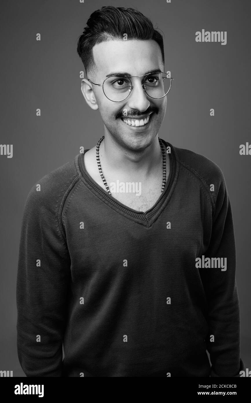 Young handsome Iranian man with mustache against gray background Stock ...