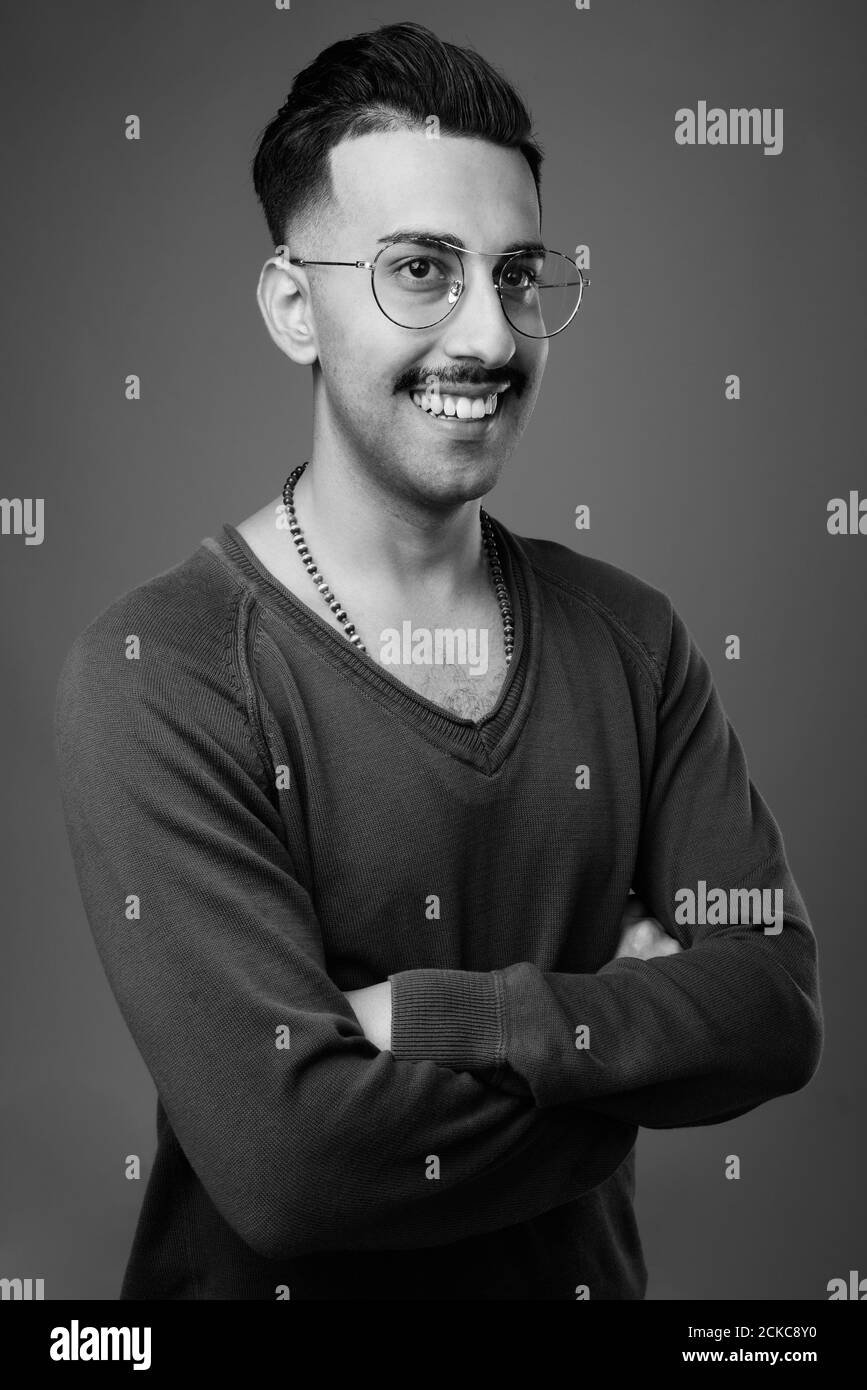 Young handsome Iranian man with mustache against gray background Stock ...
