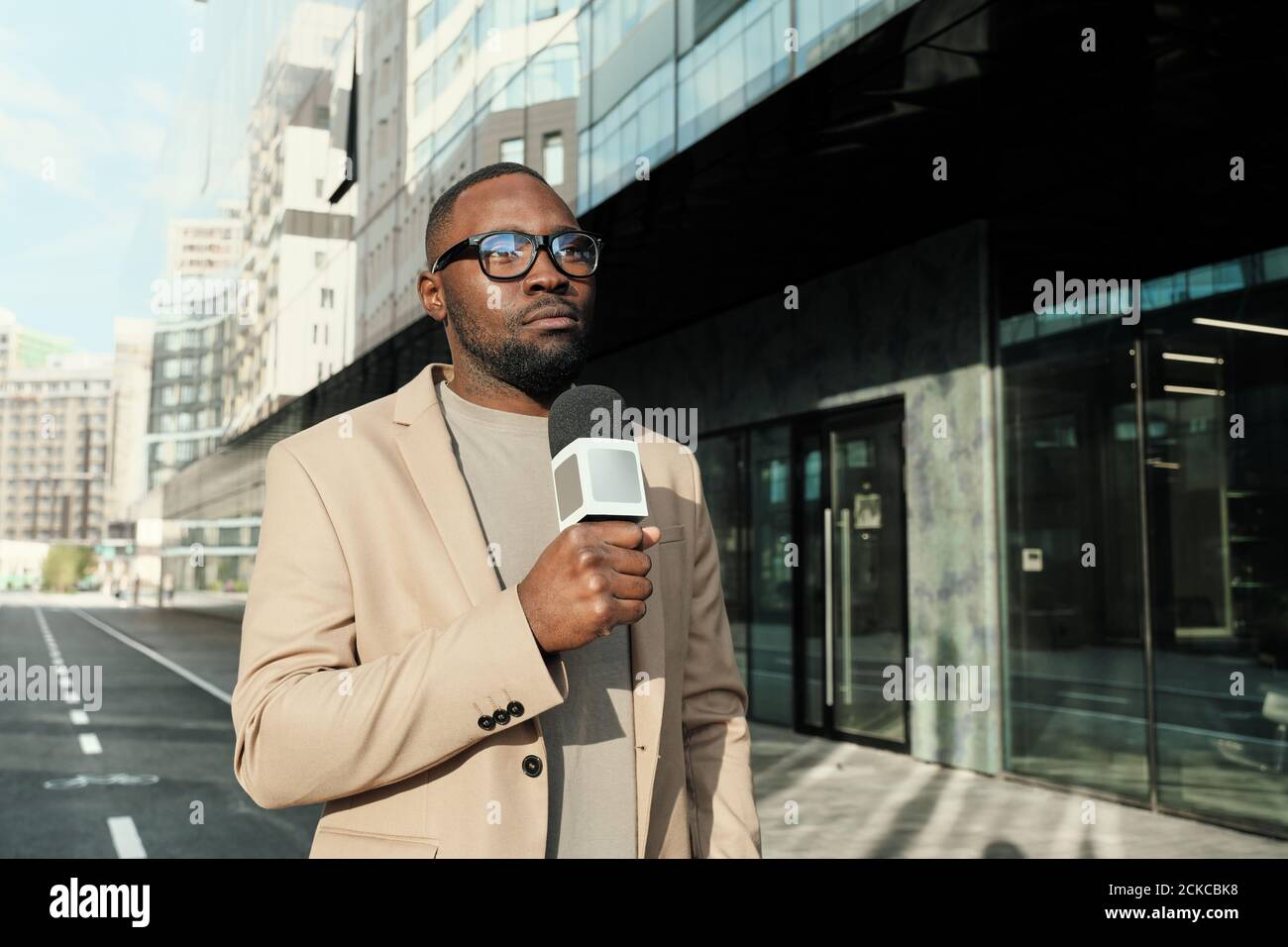 African reporter holding microphone and speaking he working in news ...