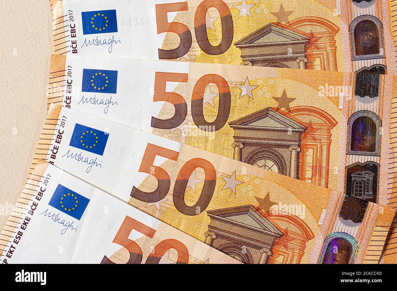 Fragment of the 50 fifty euro banknote on a beige background. Close up ...