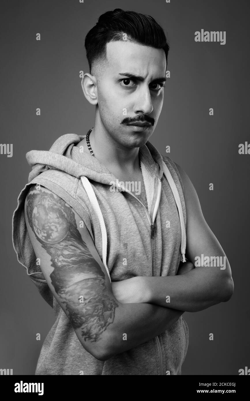 Young handsome Iranian man with mustache against gray background Stock ...