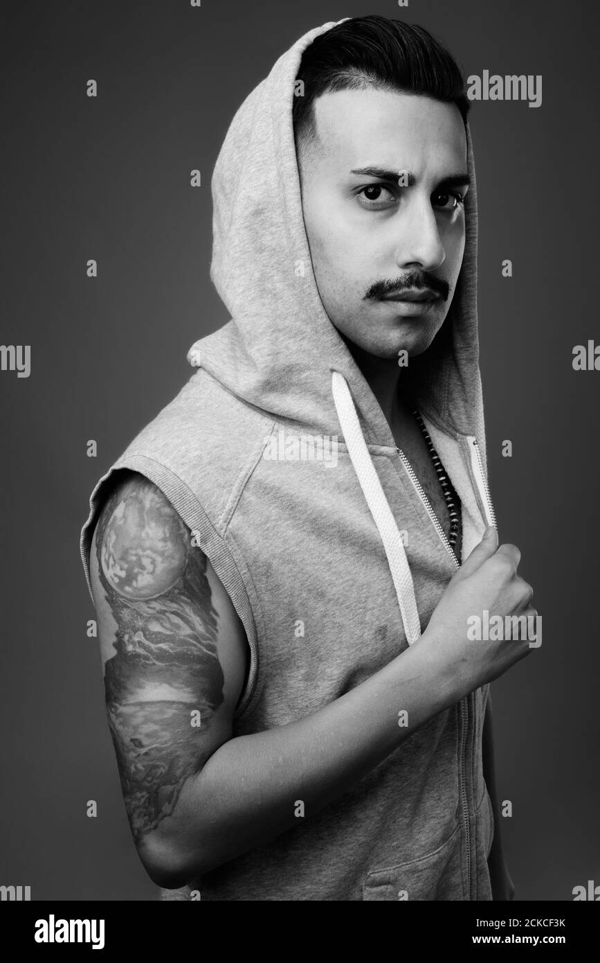 Young handsome Iranian man with mustache against gray background Stock ...