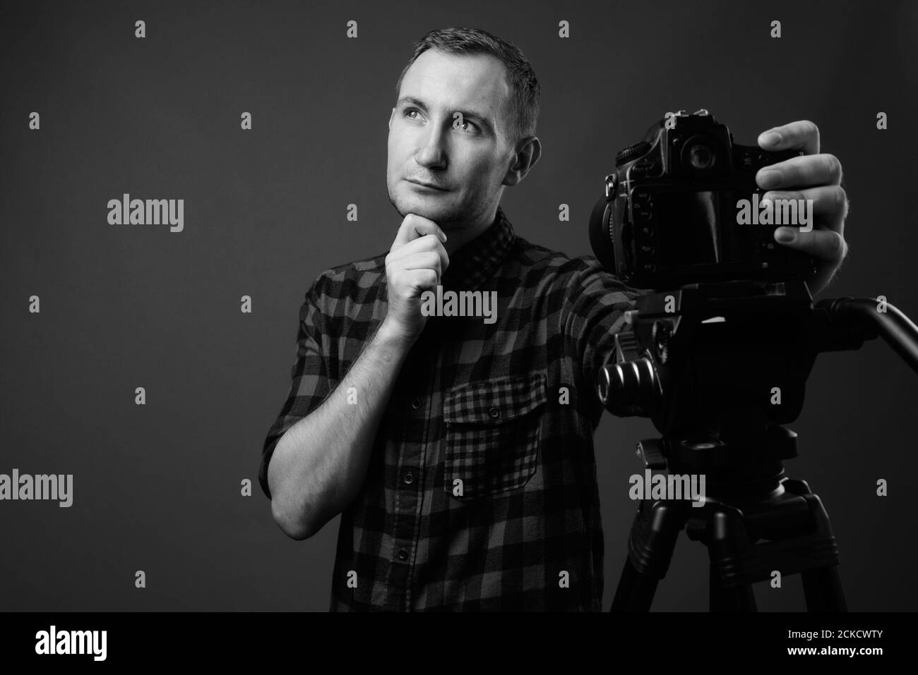 Portrait of hipster man vlogging with camera against gray background ...