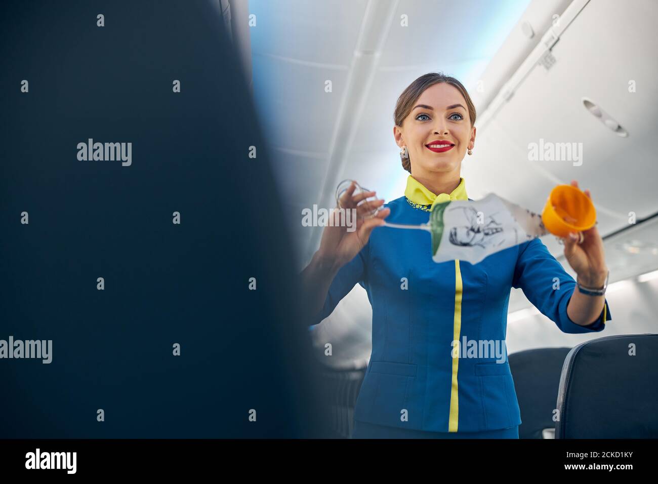 Close up portrait of young attractive flight attendant demonstrating ...