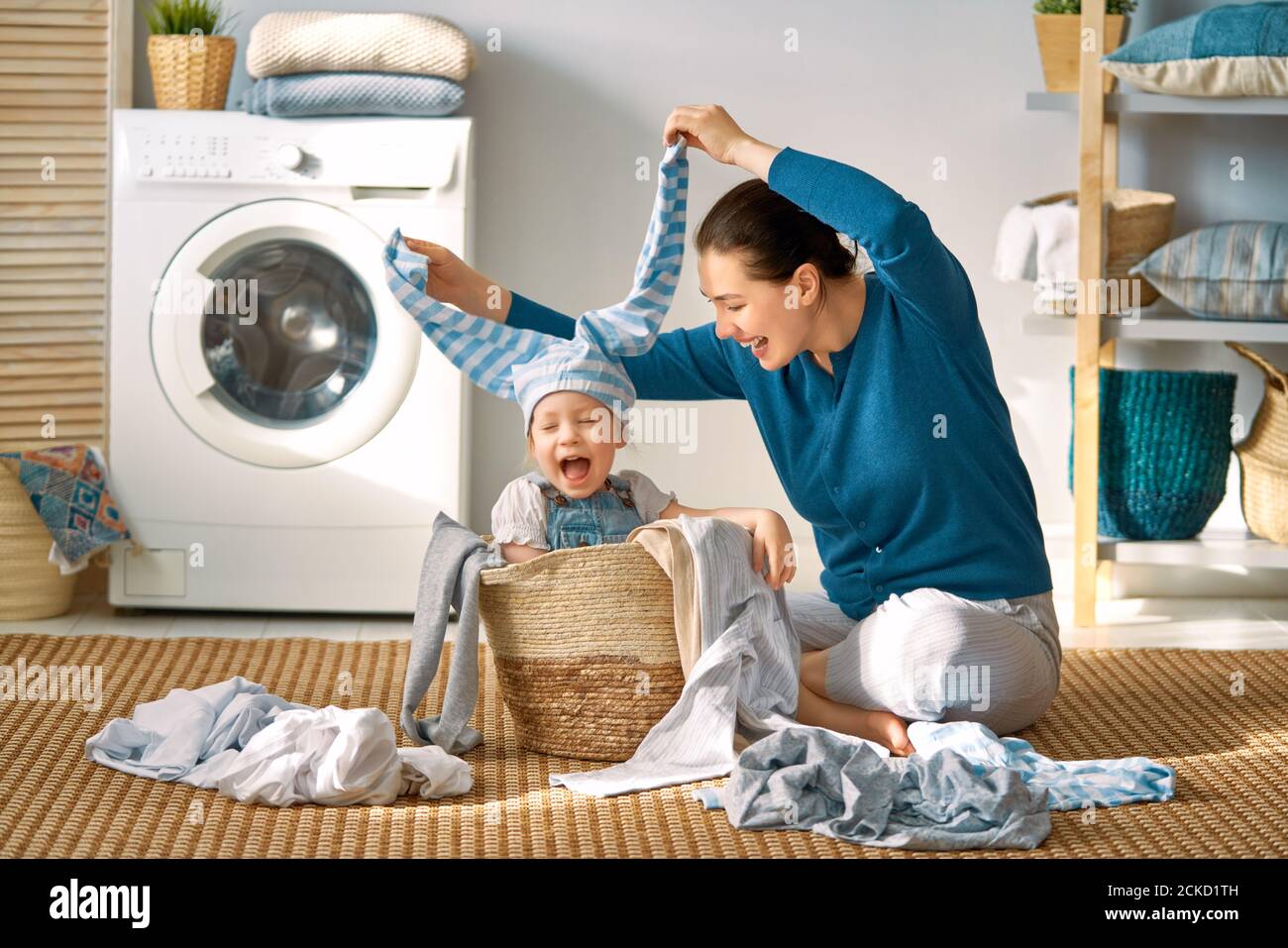 Beautiful young woman and child girl little helper are having fun and smiling while doing ...