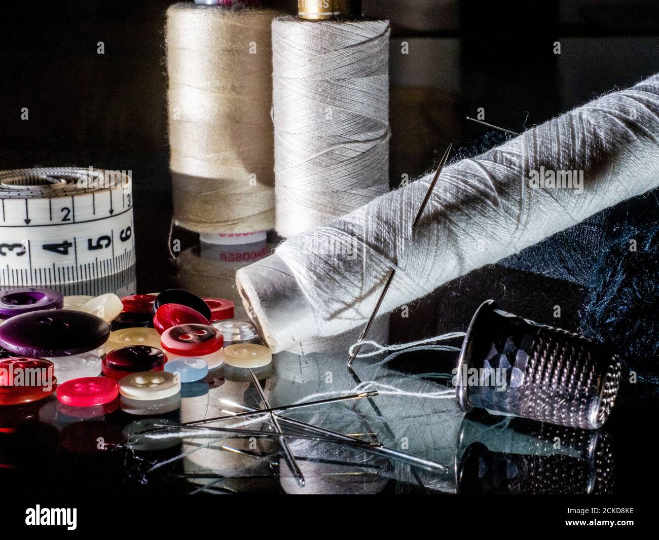 Still life of sewing items on a glass background Stock Photo - Alamy