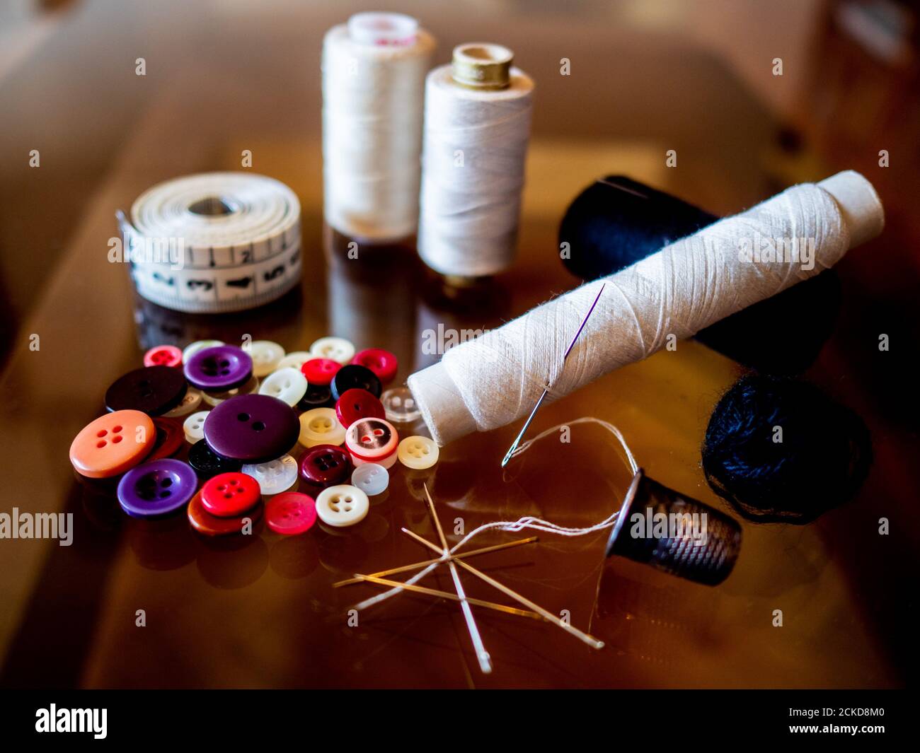 Still life of sewing items on a glass background Stock Photo - Alamy