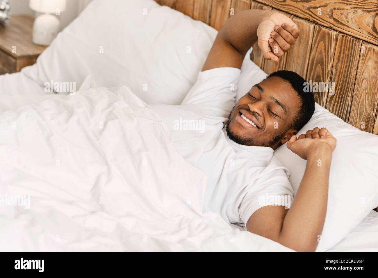 Rested Black Man Waking Up Lying In Bed At Home Stock Photo - Alamy