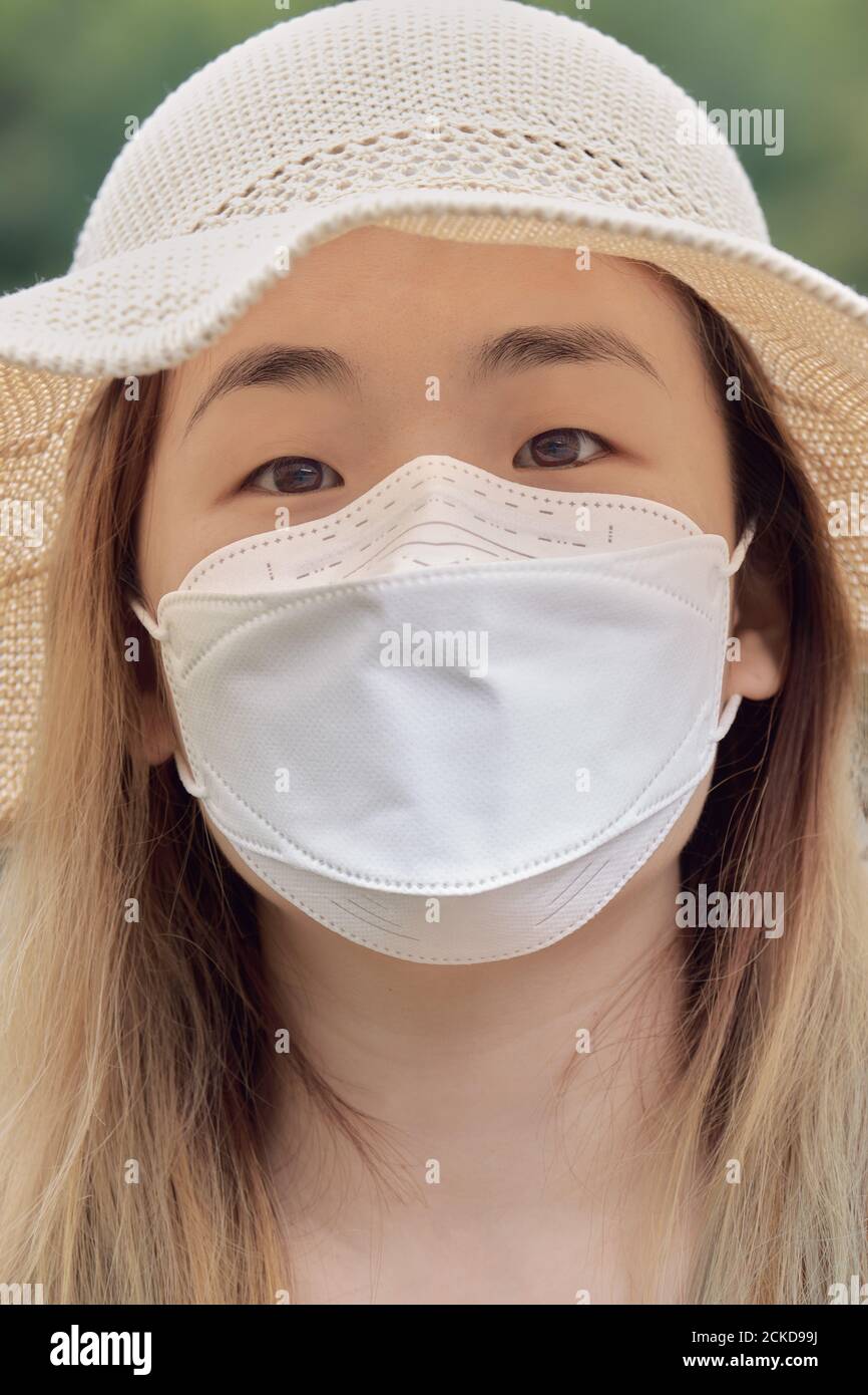 Korean girl wearing an ffp2 mask and a hat Stock Photo - Alamy