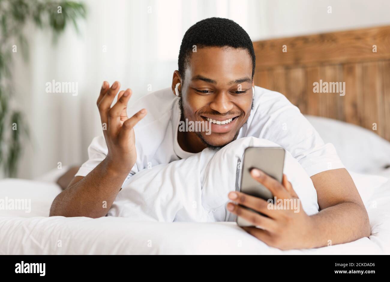 Happy Black Man Making Video Call Lying In Bed Indoors Stock Photo - Alamy