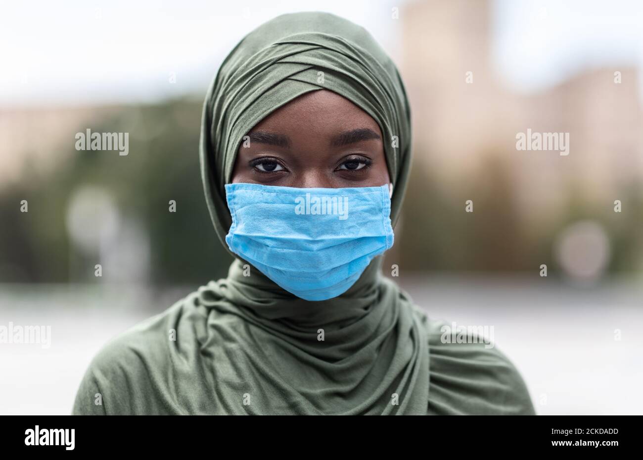 Portrait of black muslim woman wearing blue medical protective face ...