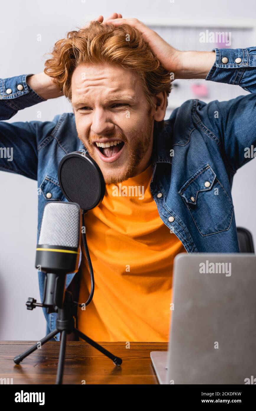 angry announcer touching head while screaming in microphone at ...