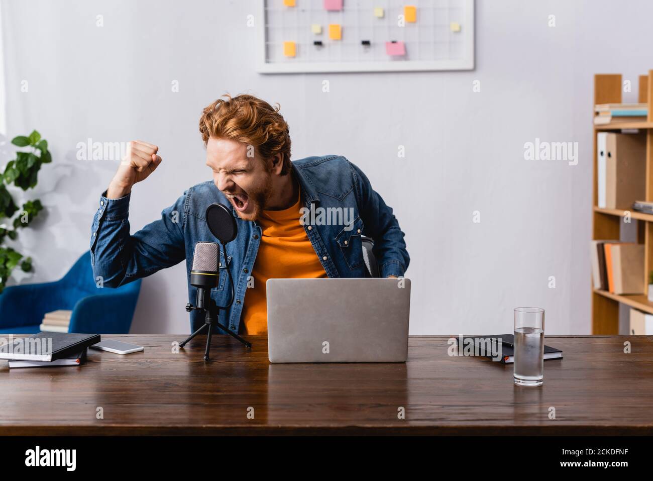 angry redhead announcer screaming in microphone and showing clenched ...