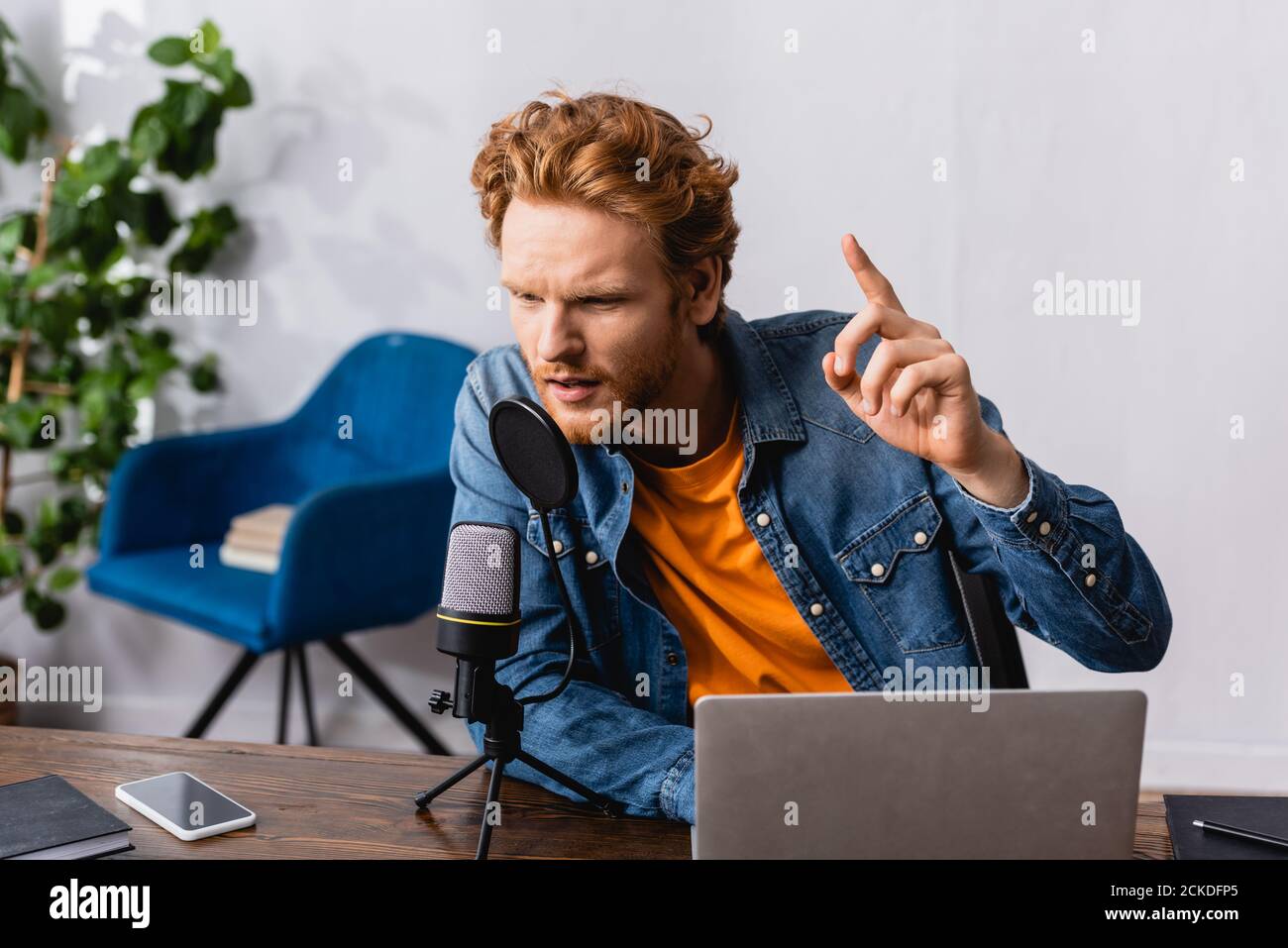 redhead announcer showing idea gesture while speaking in microphone ...