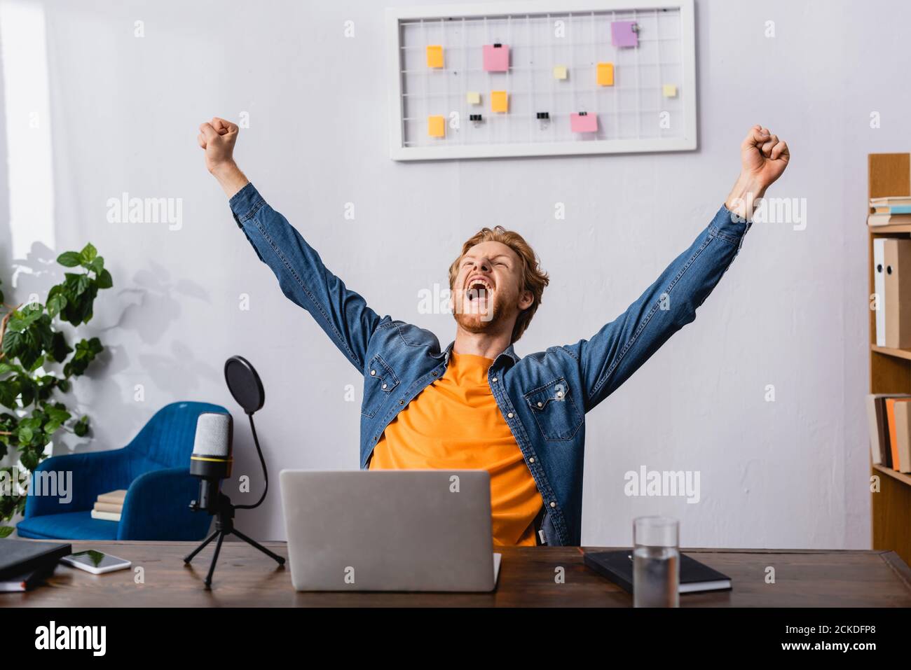 excited radio host showing triumph gesture while screaming near ...