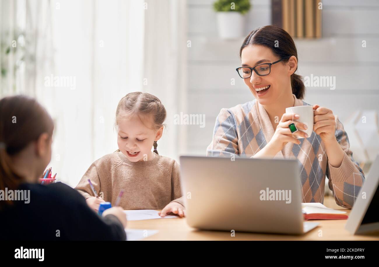 Young mother with children working on the computer. Family at home ...