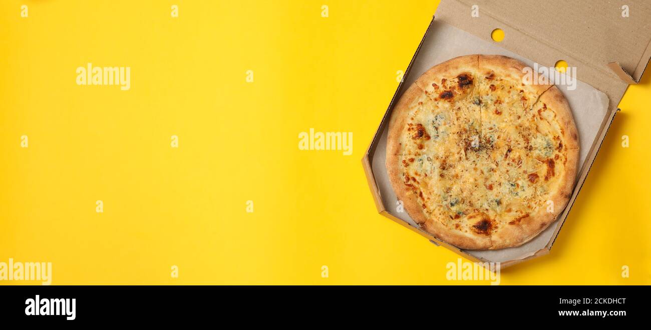 Cheese pizza in carton box on yellow background Stock Photo - Alamy