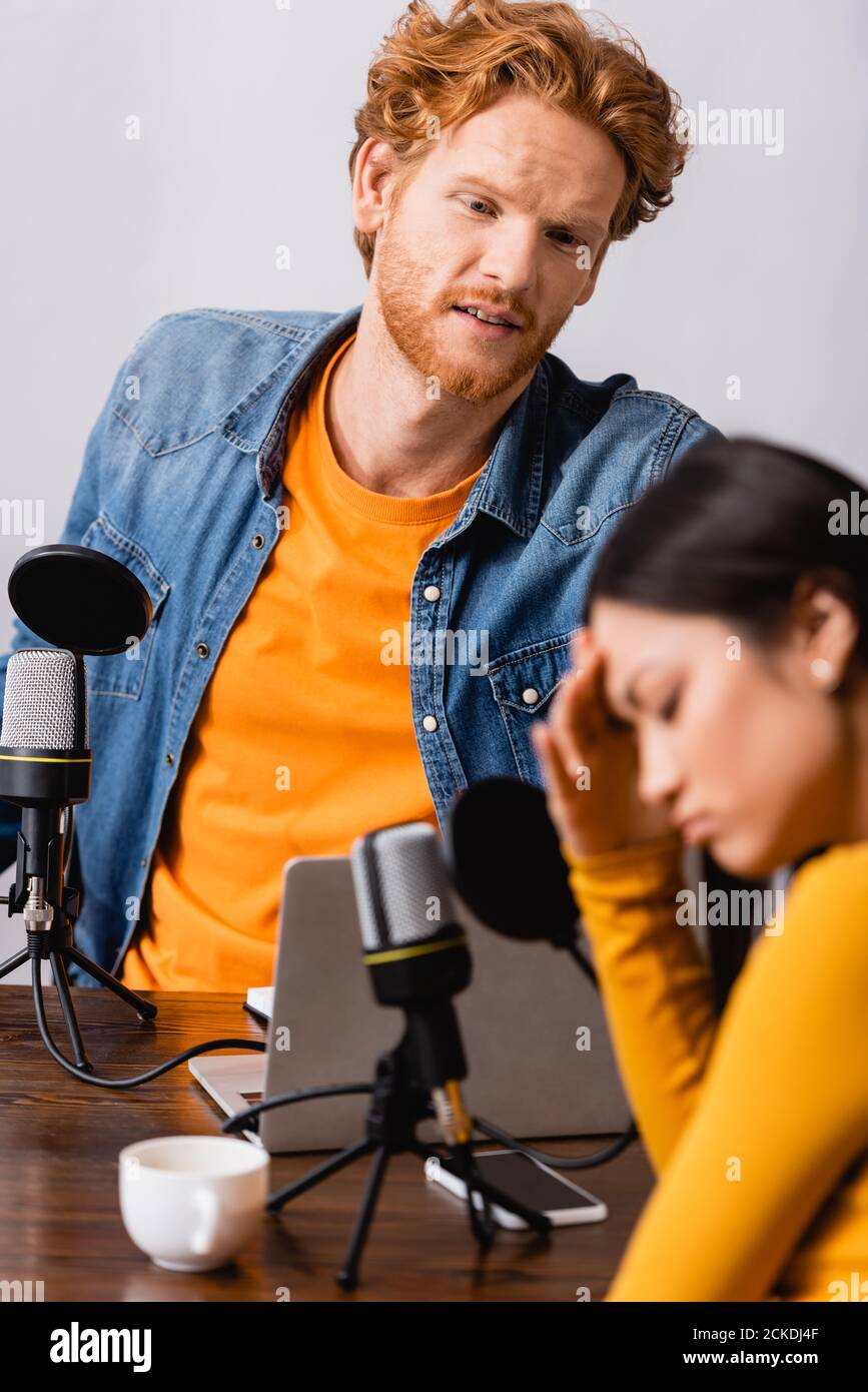 selective focus of sad asian woman with closed eyes touching head ...
