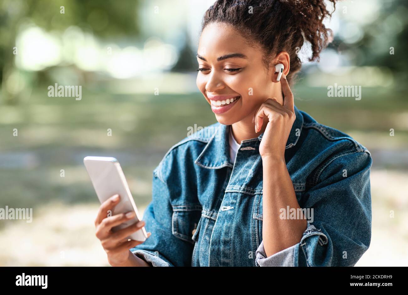 Black Millennial Girl Using Phone Making Video Call Siitting Outside ...