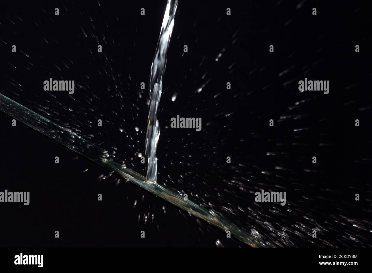 Water falling on a glass and generating a big splash and splash on a ...