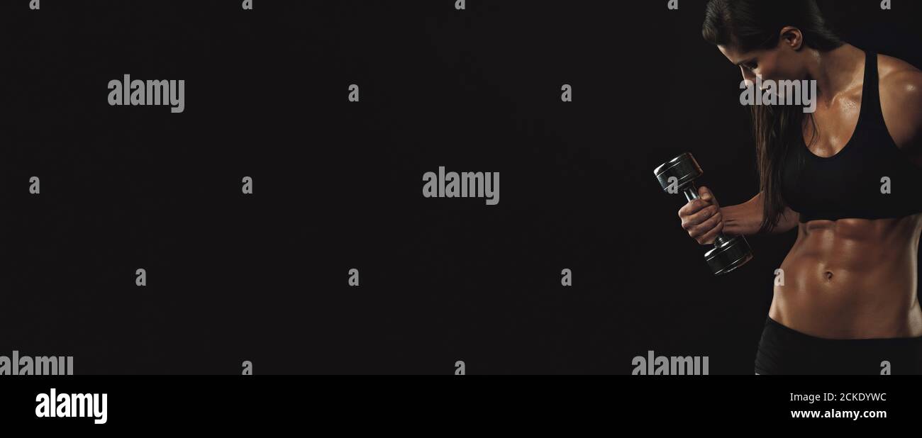 Female fitness model exercising with dumbbell. Young female bodybuilder ...