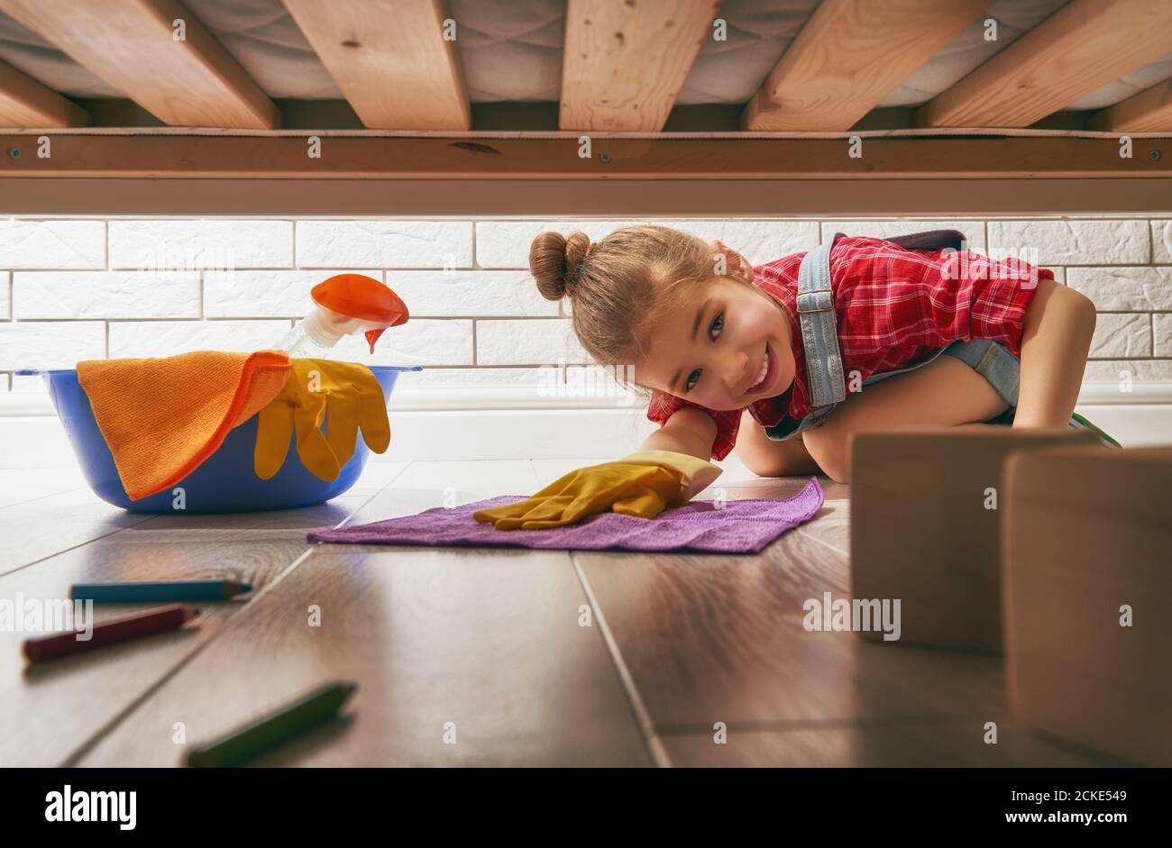 Charming little helper. Cute little child girl makes cleaning the house ...
