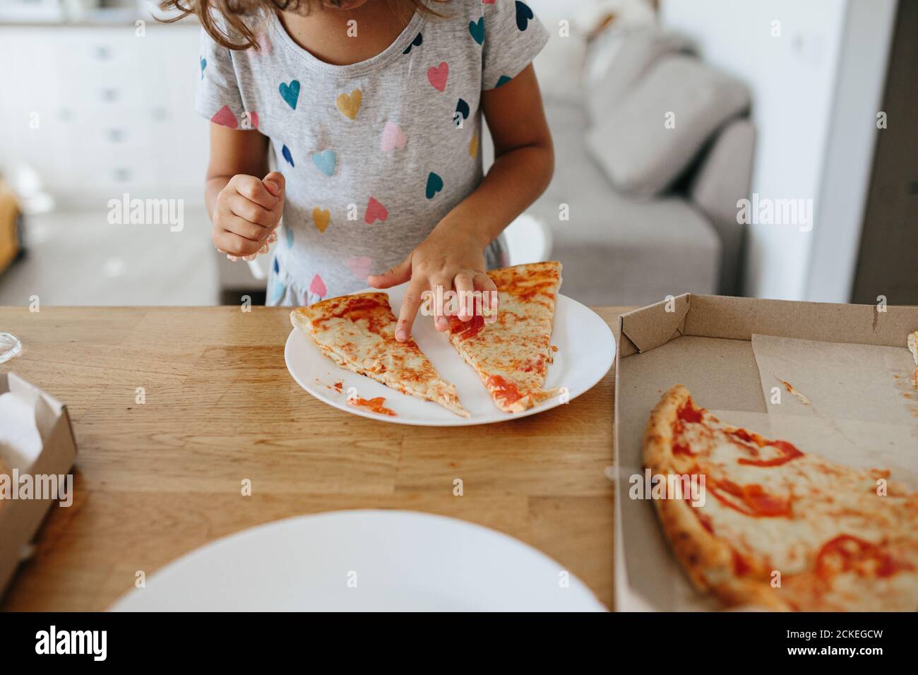 Happy time of eating concept. Kids girl eating pizza at home. Adorable ...