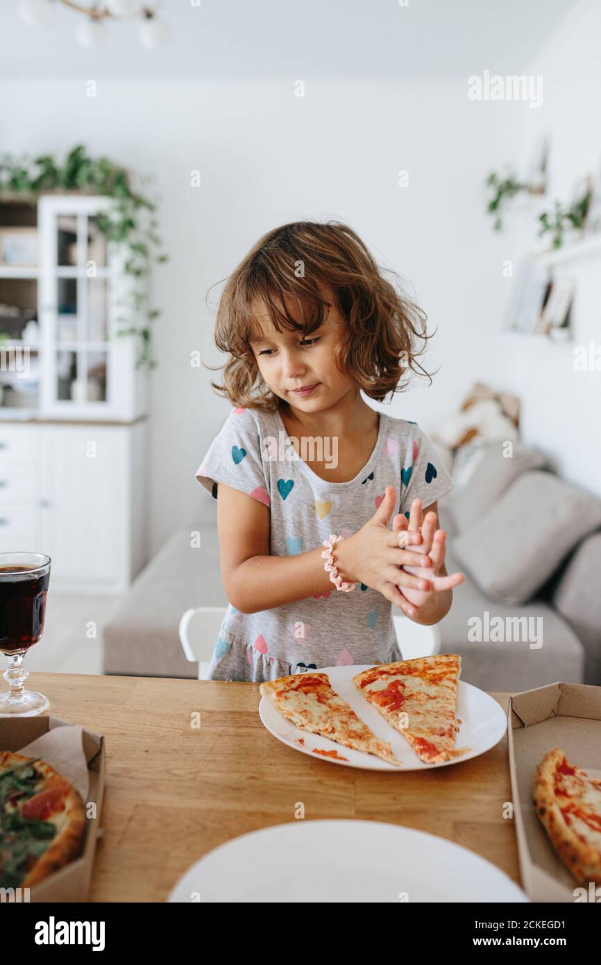 Happy time of eating concept. Kids girl eating pizza at home. Adorable ...