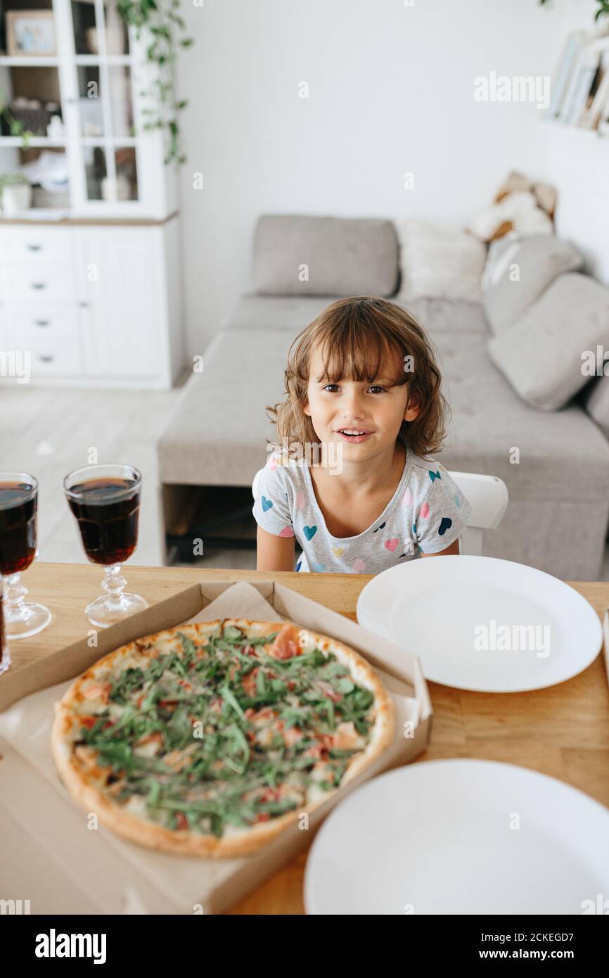 Happy time of eating concept. Kids girl eating pizza at home. Adorable ...