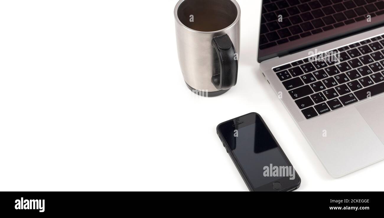 Coffee cup with laptop and cell phone isolated on white background ...