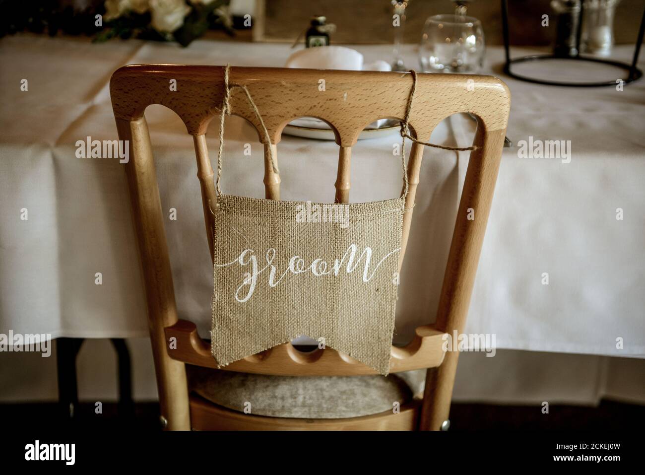 Grooms name in white writing on hessian flag hung on wooden chair Stock ...