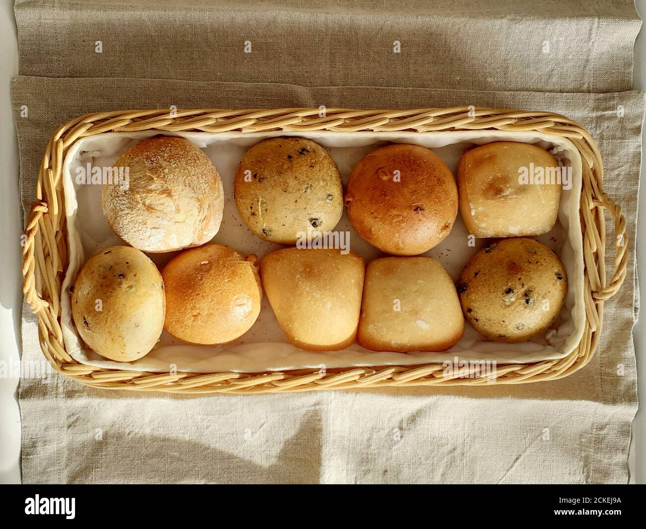 Bread buns in a basket under natural light Stock Photo - Alamy