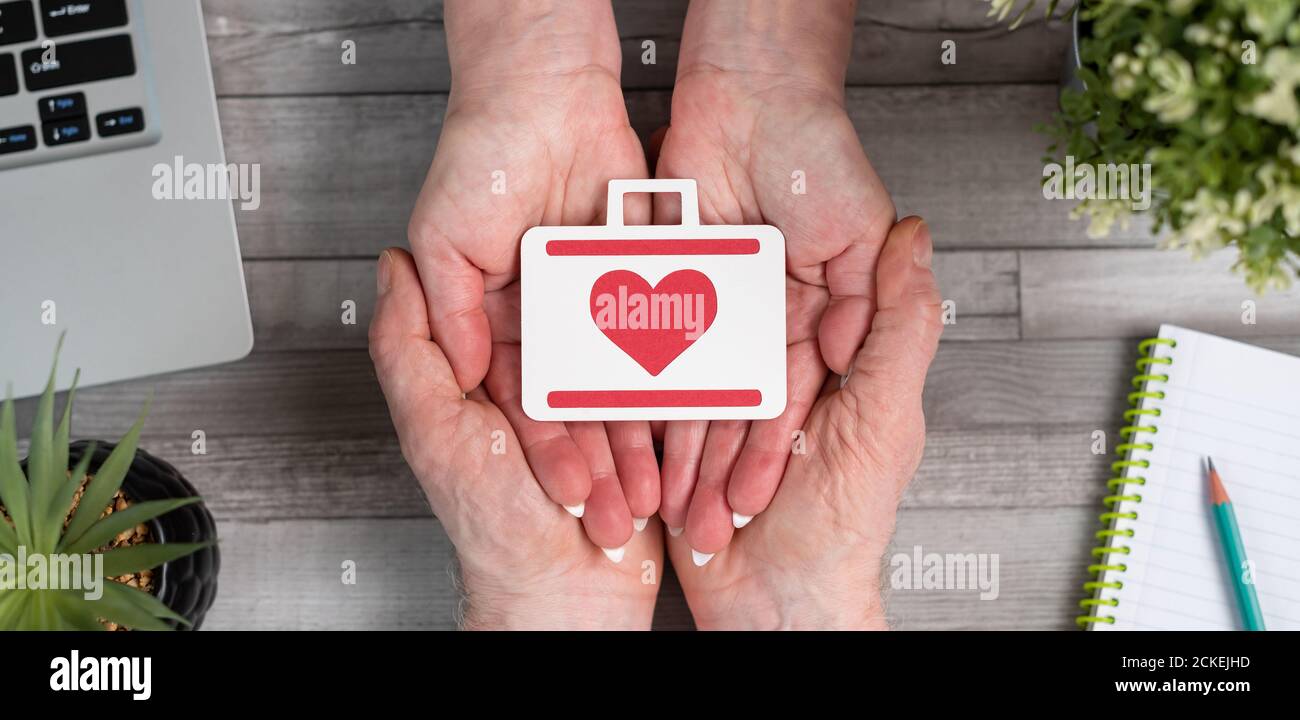 Hands holding a paper medical briefcase; Symbol of health insurance ...