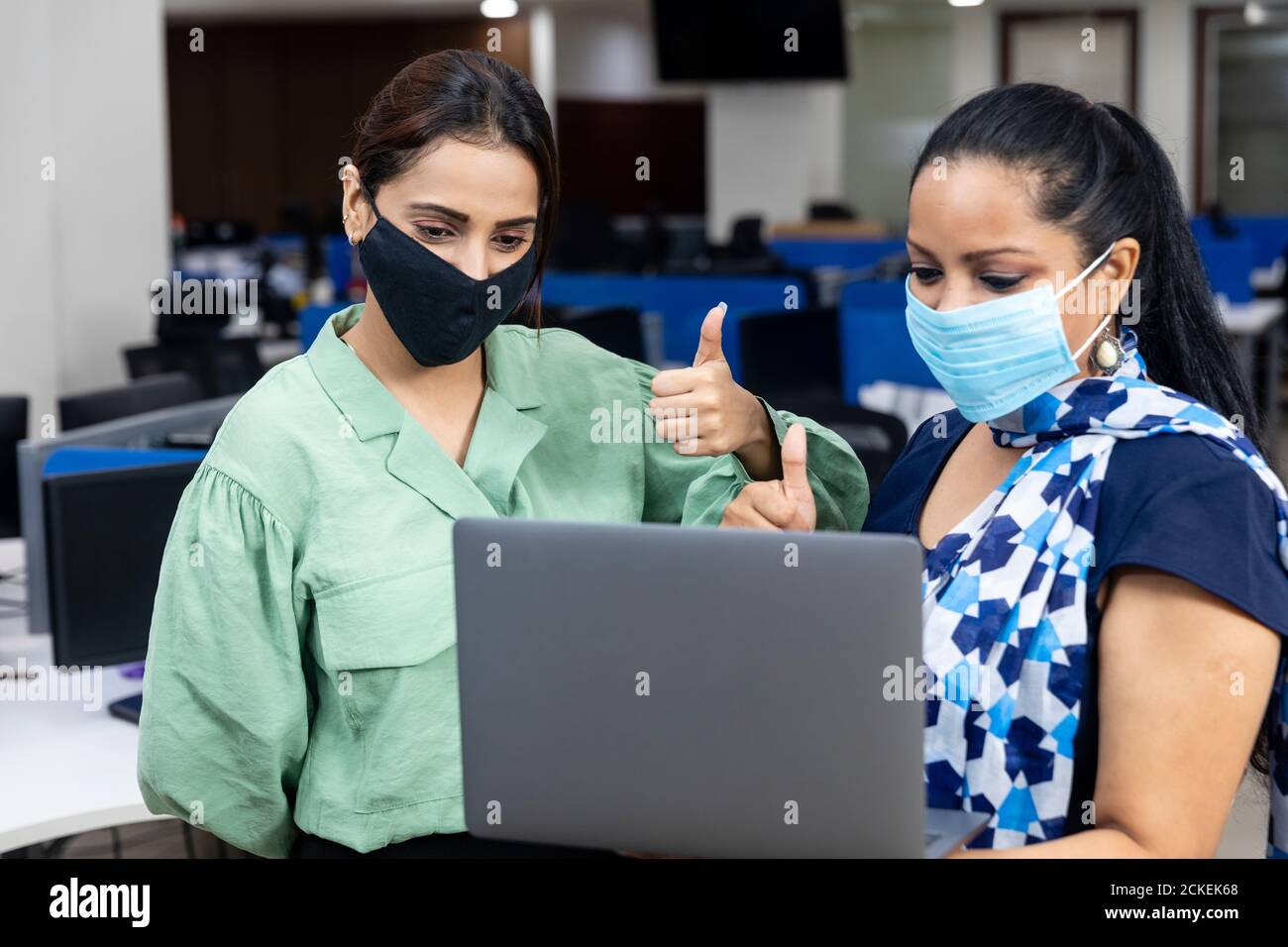 Portrait of two young Indian businesswomen wearing covid protection ...