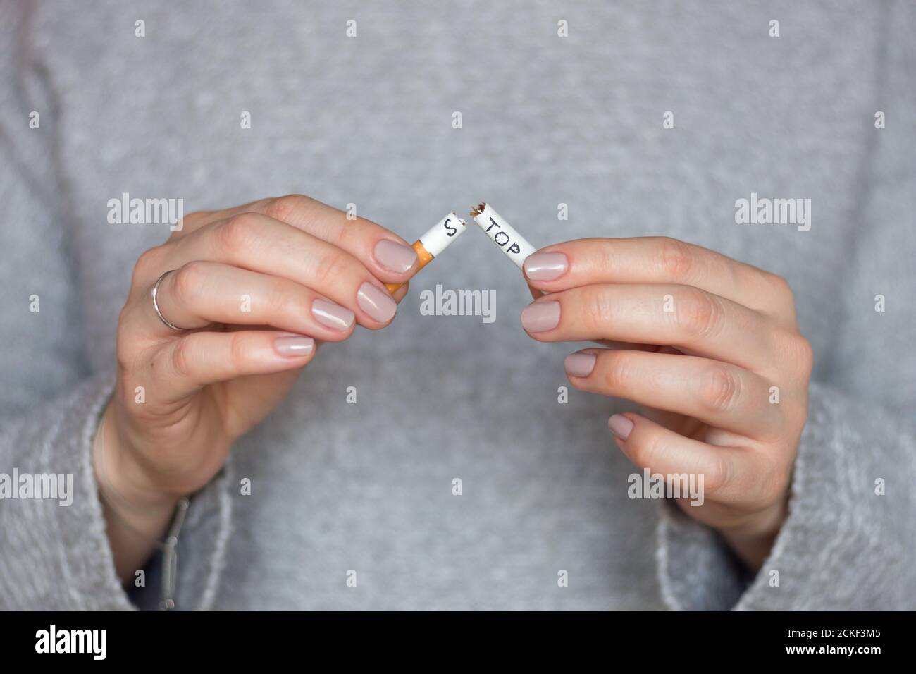 stop smoking cigarettes concept. girl breaks a cigarette with the words ...