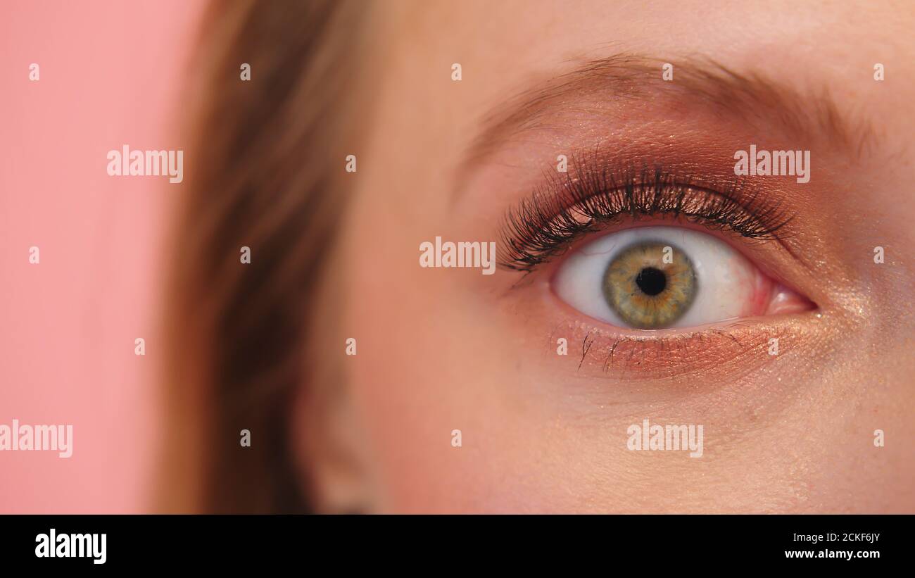 macro shot of scared surprised green woman eye with eye shadow isolated ...