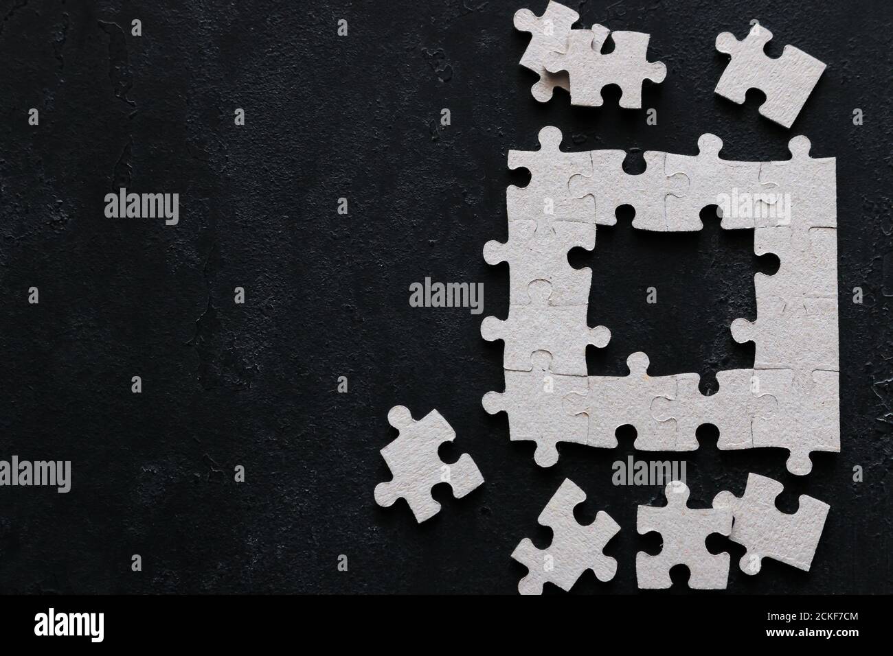 puzzle with missing parts on a black background with space for text ...