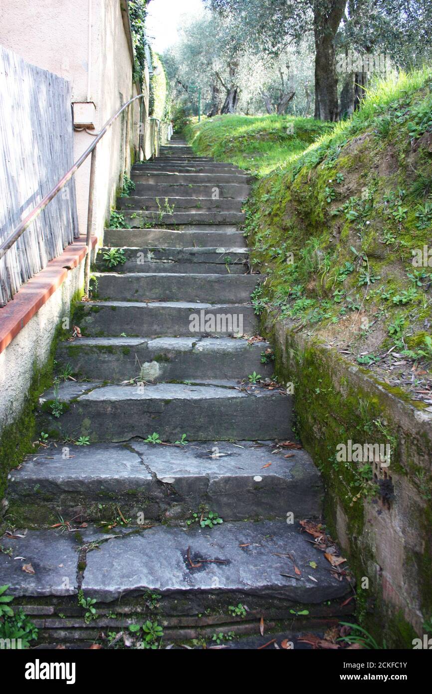 old steep stairway uphill in rock, long endless. path that runs along ...
