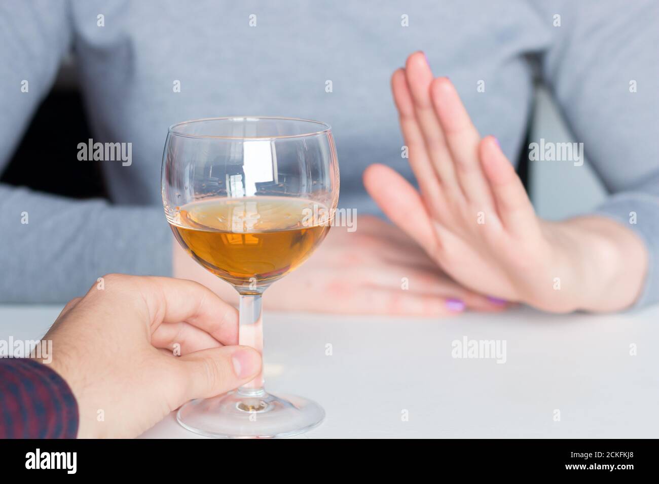 man offer alcohol but woman refuses Stock Photo - Alamy