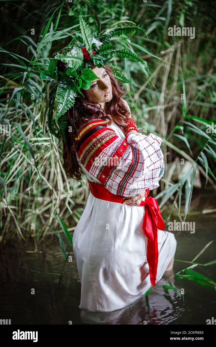 beautiful woman in wreath of wild flowers of flowers in sunny day ...